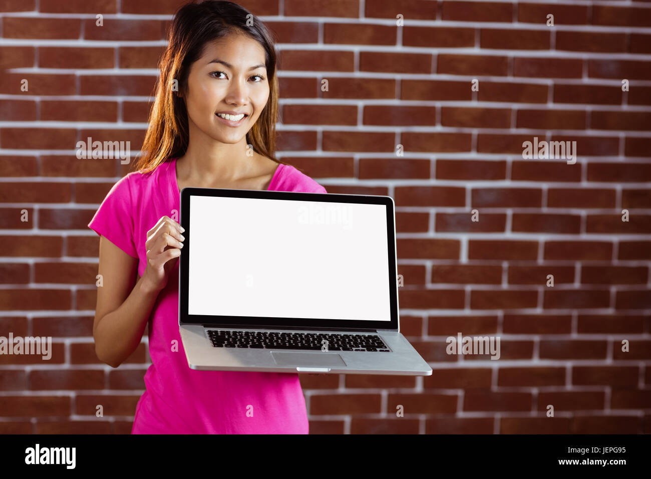 Smiling asian woman holding computer Stock Photo - Alamy