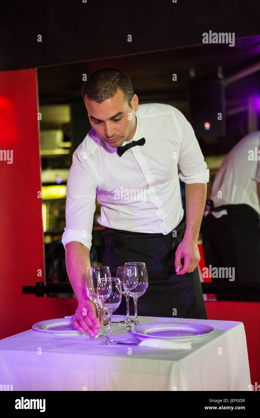 Waiter setting a table Stock Photo - Alamy