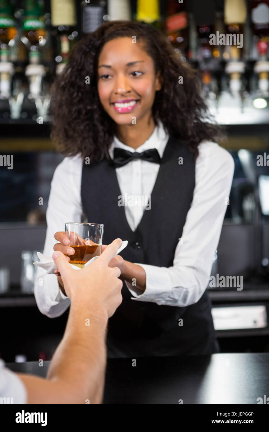 Female barmaid serving a glass of whiskey Stock Photo - Alamy