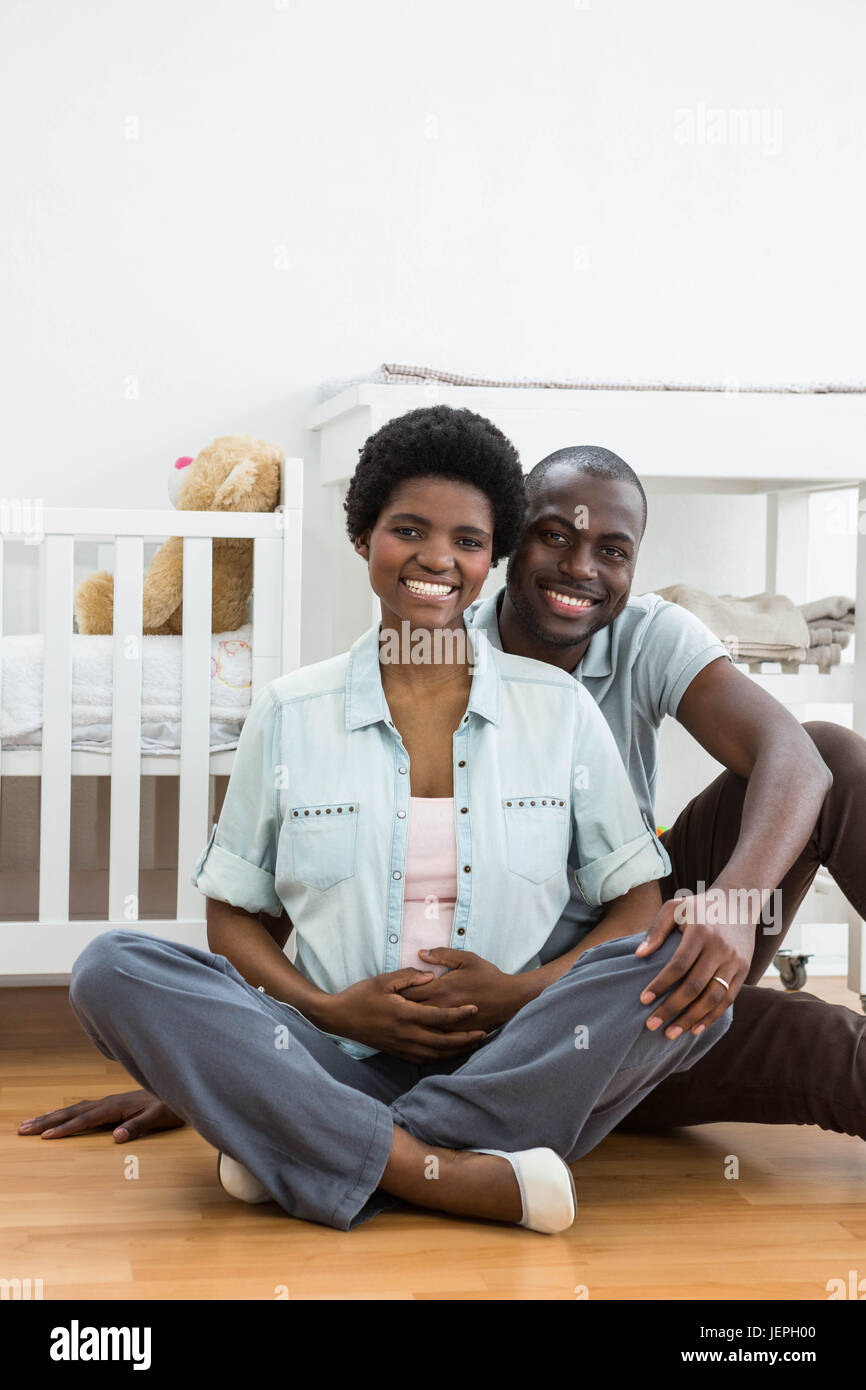 Pregnant couple sitting near baby cradle Stock Photo - Alamy