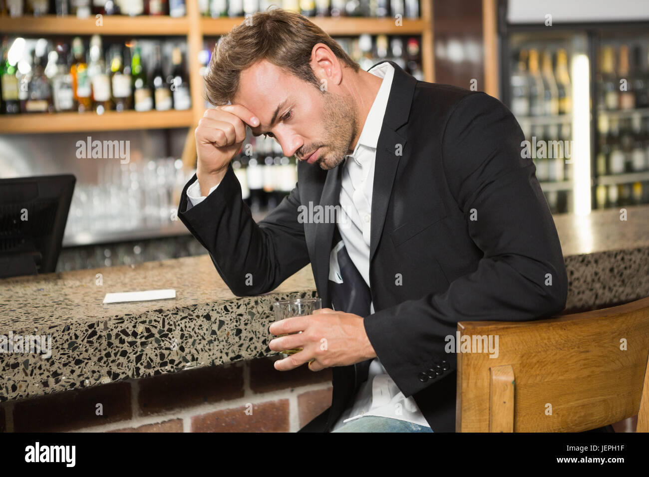 Tired man having a whiskey Stock Photo - Alamy