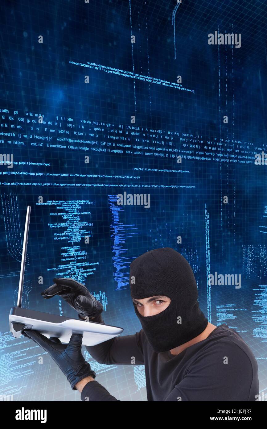 Masked man using laptop Stock Photo - Alamy