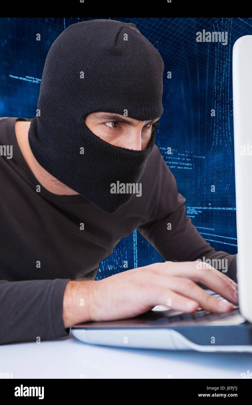 Hacker using laptop Stock Photo - Alamy