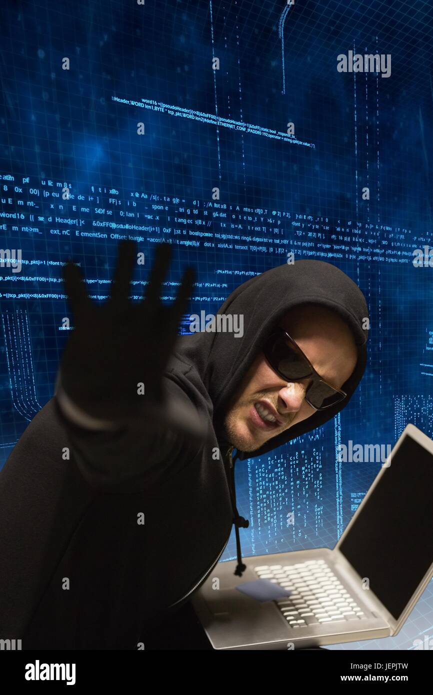 Hacker using laptop Stock Photo - Alamy