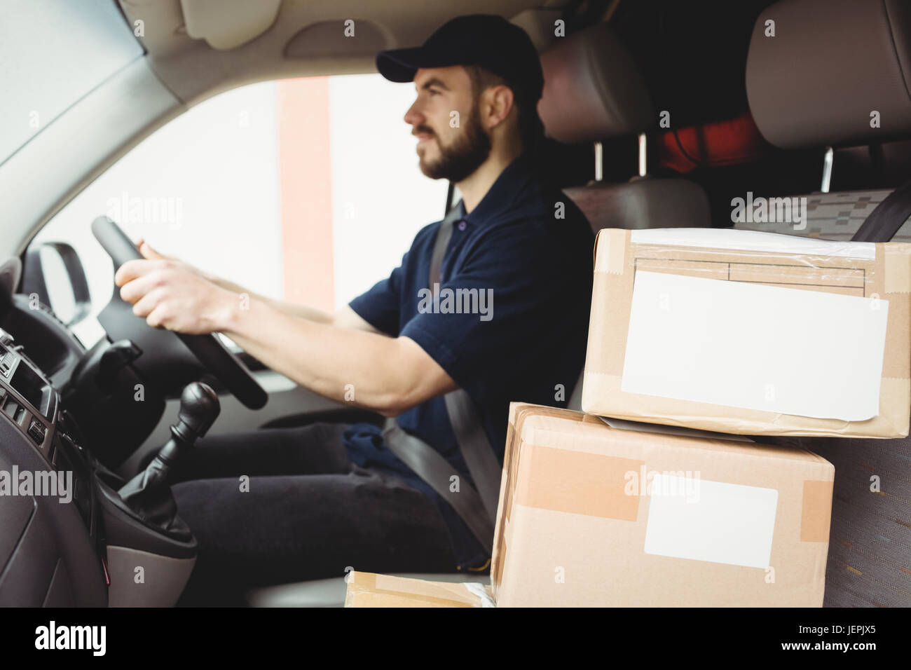 Delivery man driving his van Stock Photo - Alamy