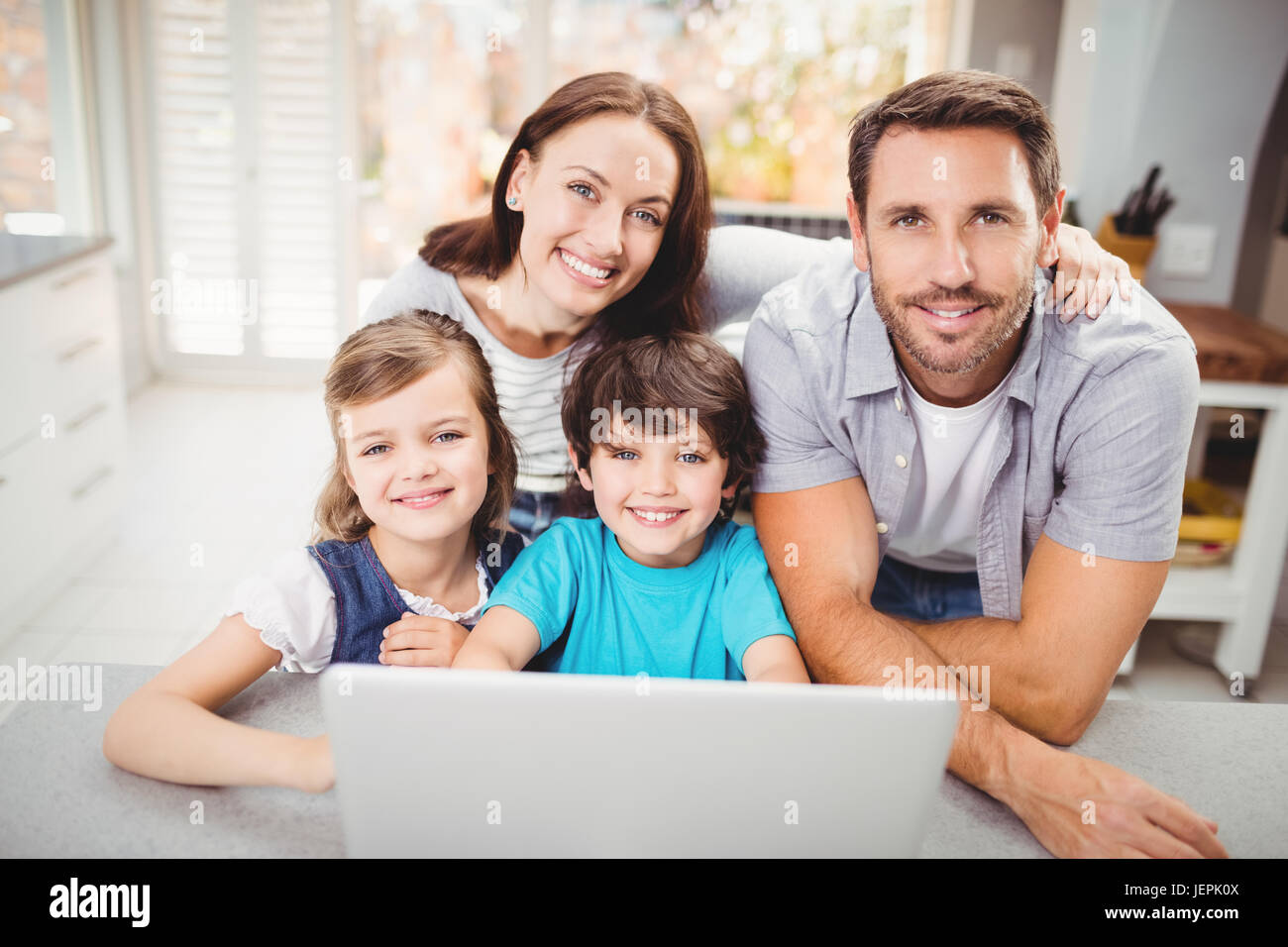 Portrait of happy family with laptop Stock Photo - Alamy