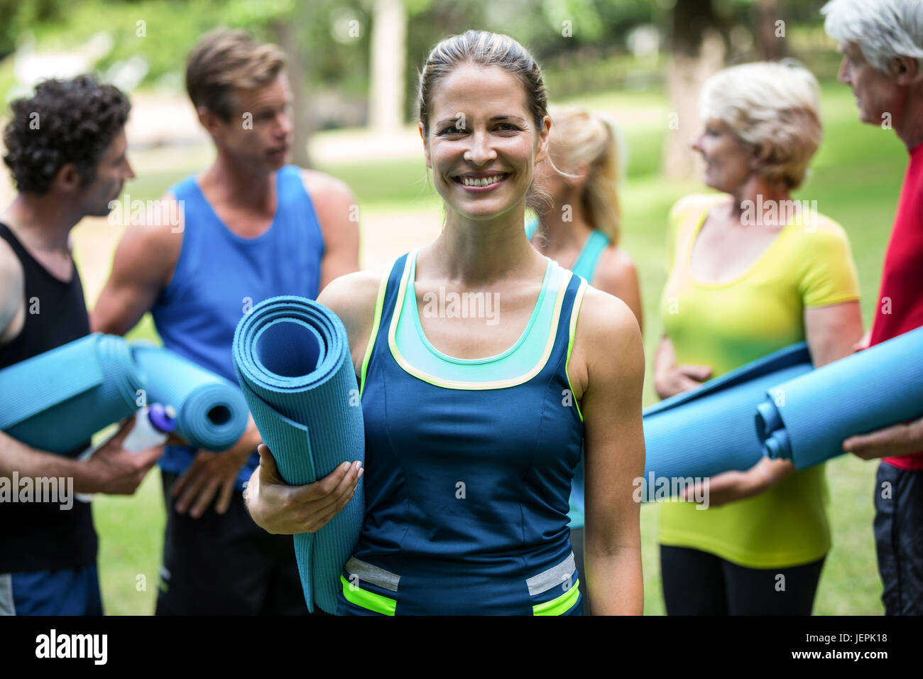 Fitness class posing with sports mats Stock Photo - Alamy