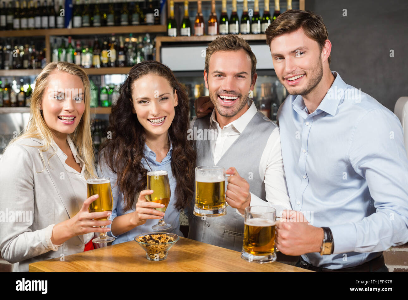 Friends toasting while looking at camera Stock Photo - Alamy