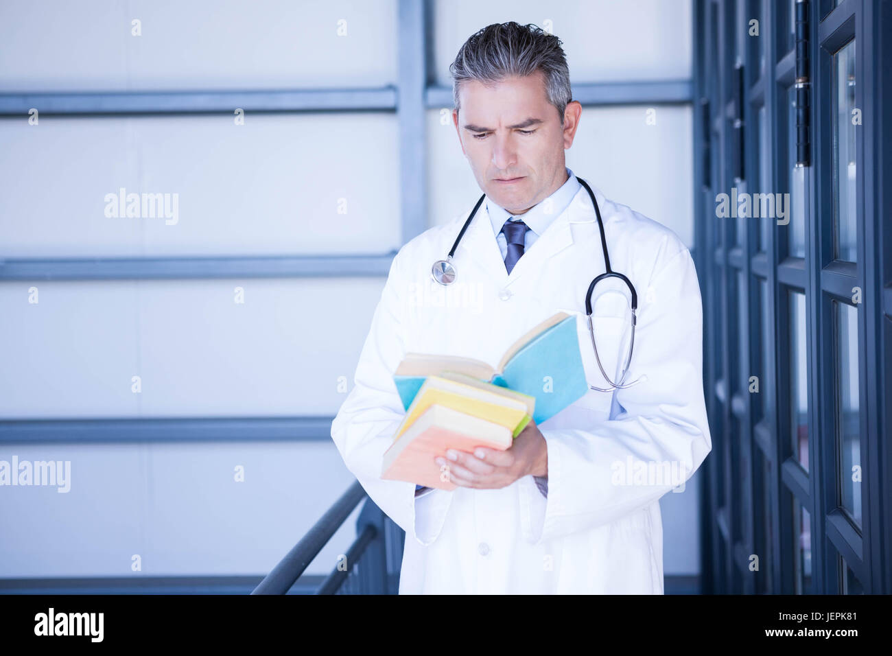 Male doctor reading medical book Stock Photo - Alamy