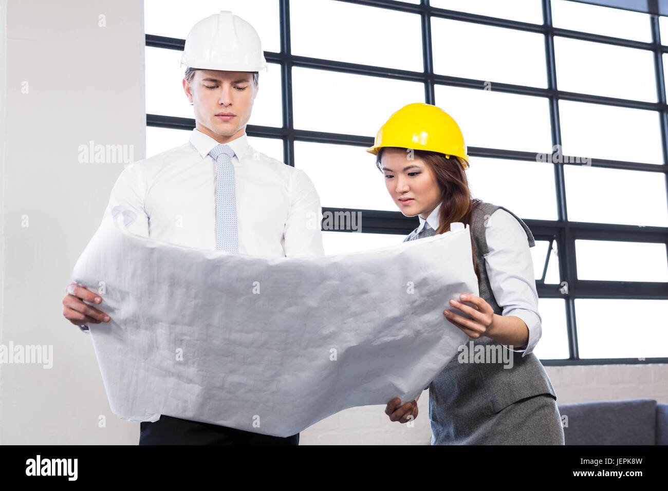 Architects looking at blueprint Stock Photo - Alamy