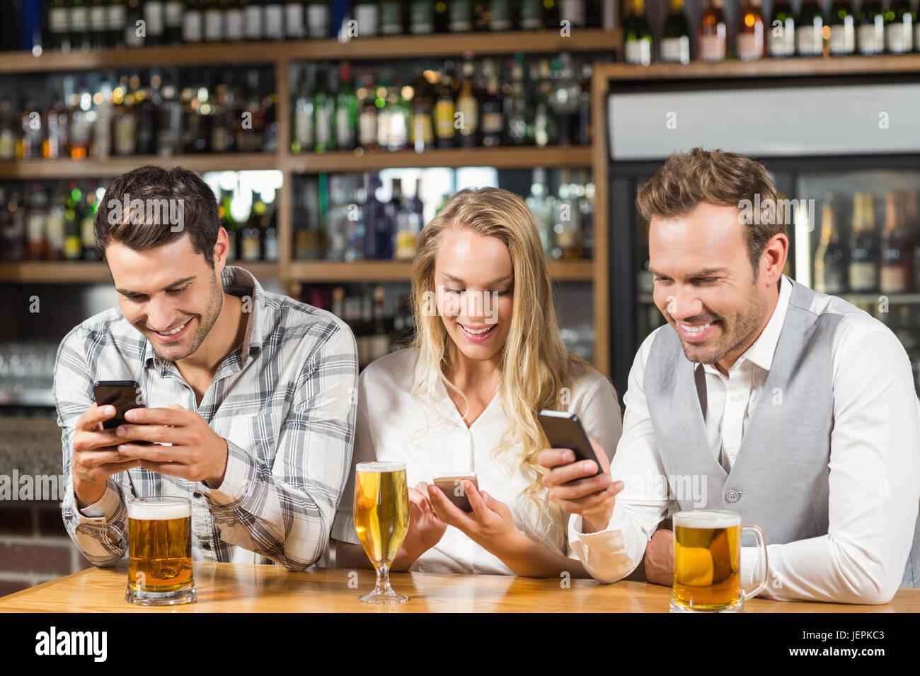 Friends looking at smart phones Stock Photo - Alamy