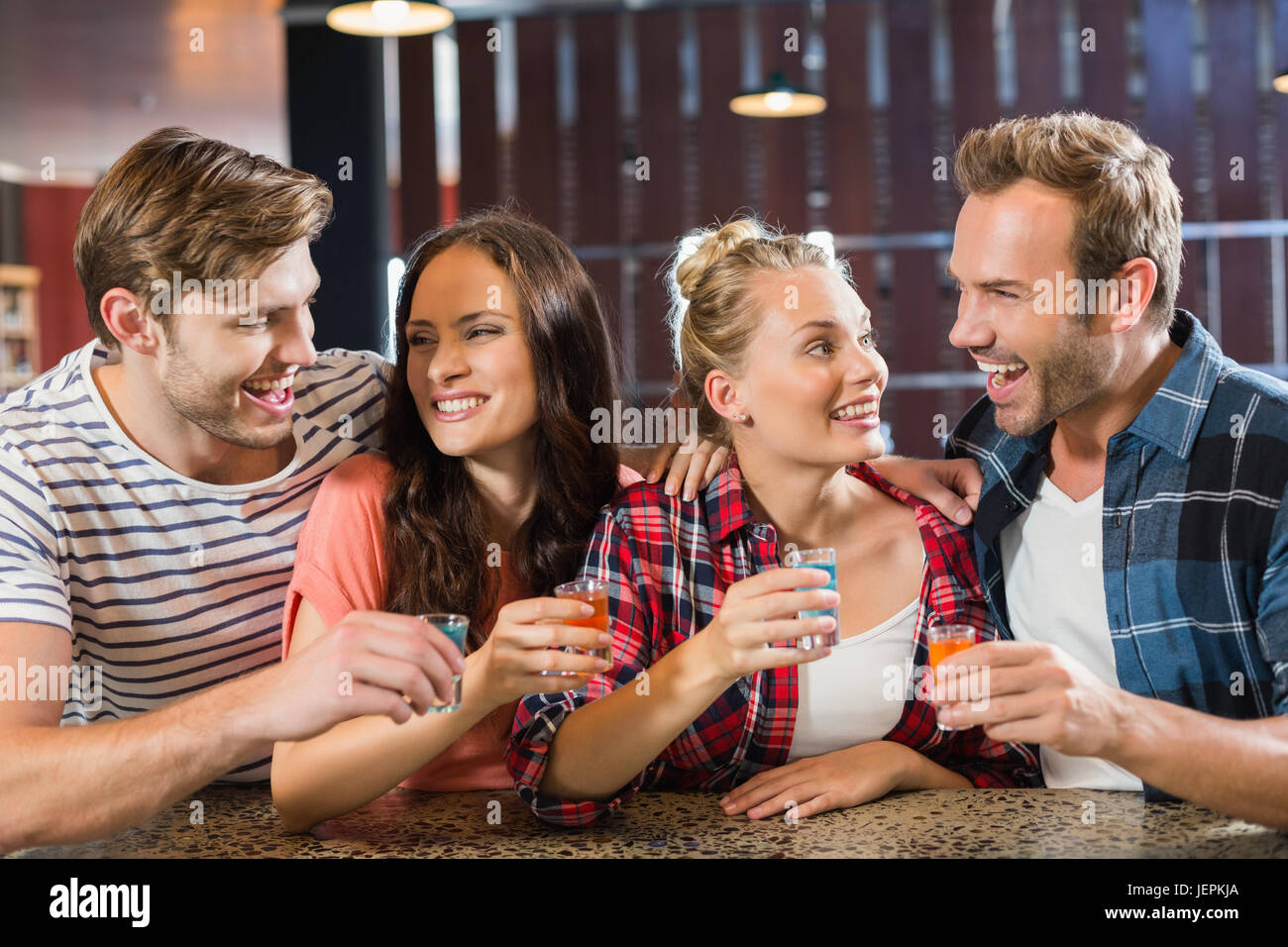 Friends laughing with shots in hand Stock Photo - Alamy