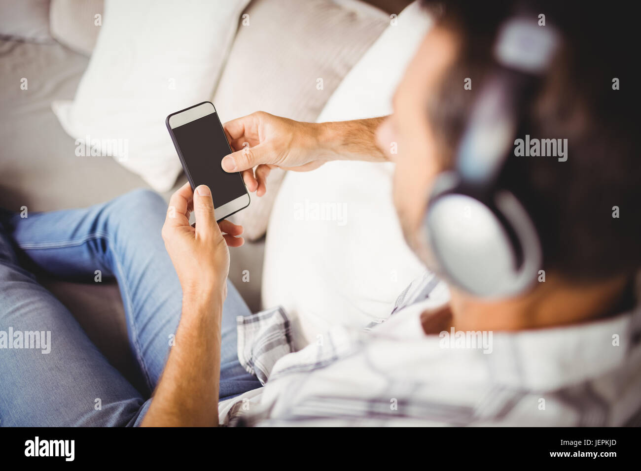 Man using mobile phone while listening music Stock Photo - Alamy