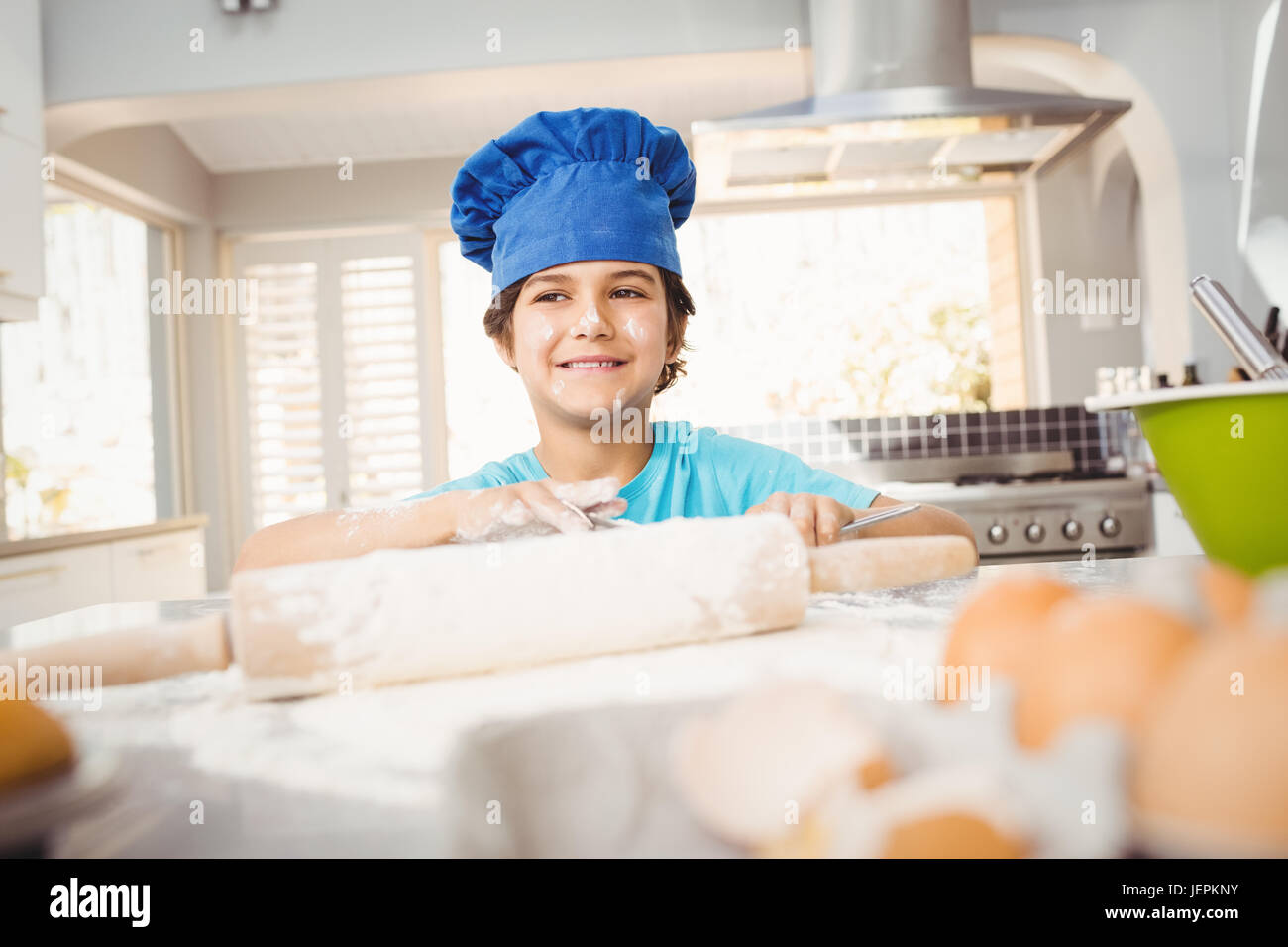 Boy smiling while preparing food by table Stock Photo - Alamy