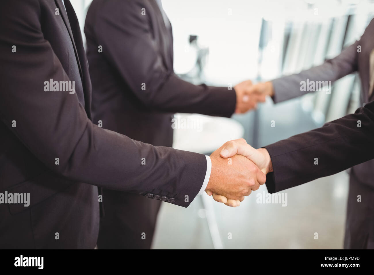Colleagues greeting other shaking hands hi-res stock photography and ...