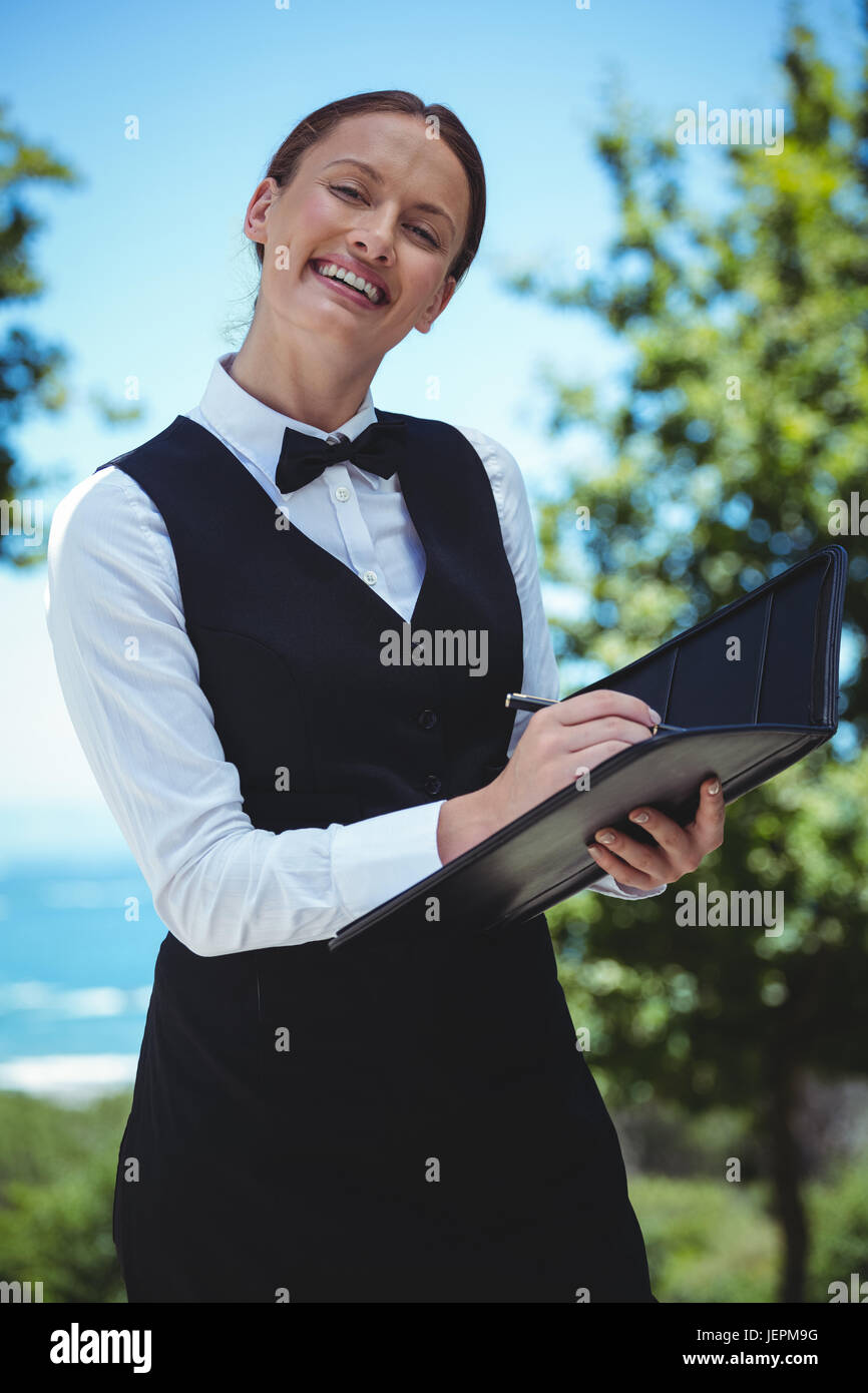 Smiling waitress taking an order Stock Photo - Alamy