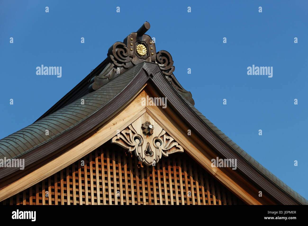 Peak end of an ornate roof with wooden carvings in the Yasukuni Shrine ...