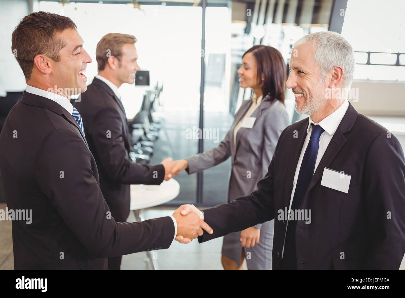 Standing leadership communication shaking hands smiling hi-res stock ...