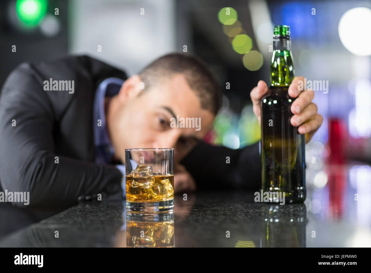 Drunk businessman slumped on bar Stock Photo - Alamy