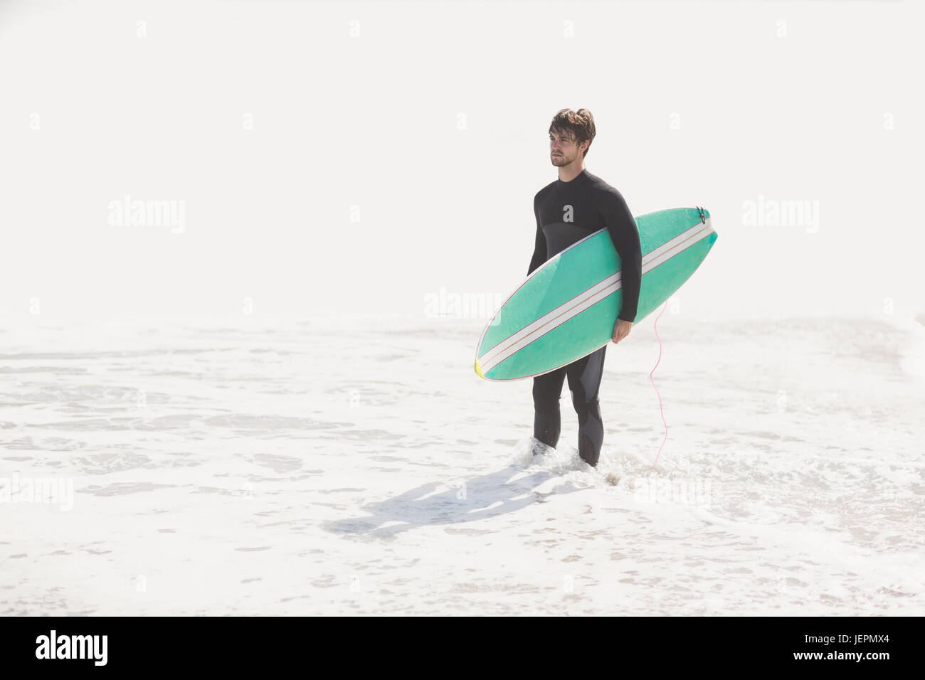 Man holding surfboard on the beach Stock Photo - Alamy