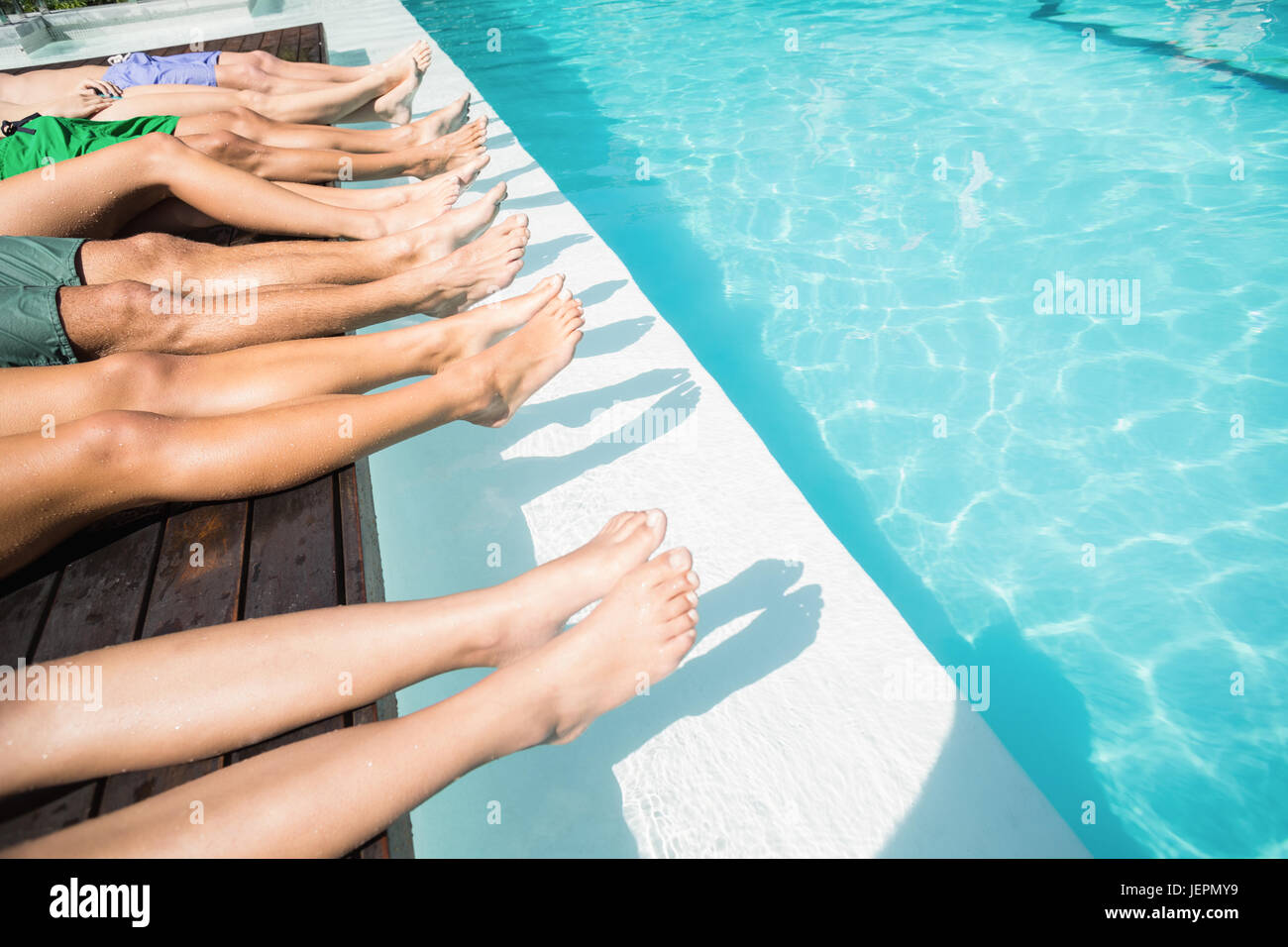 Feet of friends relaxing at poolside Stock Photo - Alamy