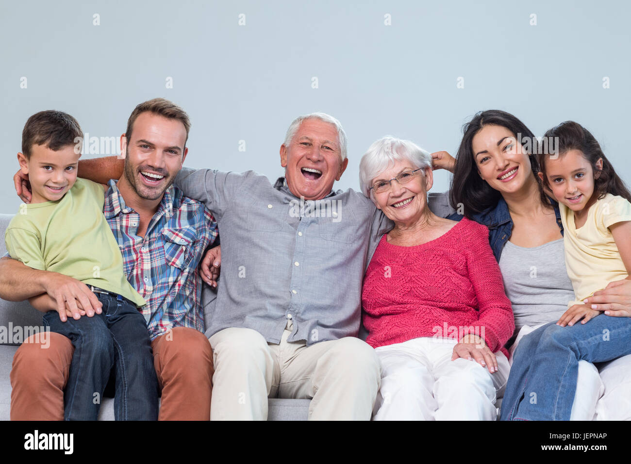 Family sitting on sofa Stock Photo - Alamy