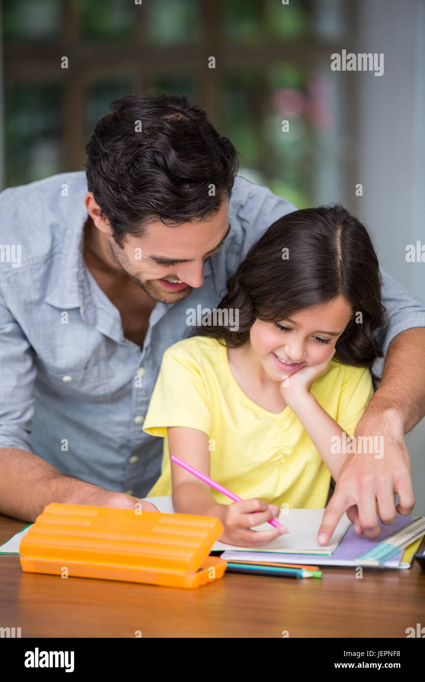 Happy father assisting daughter with homework Stock Photo - Alamy
