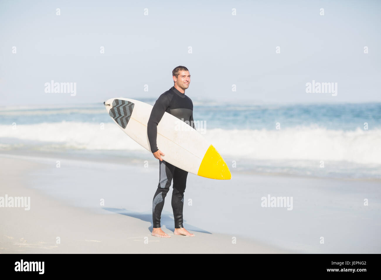 Surfer holding a surfboard on the beach Stock Photo - Alamy