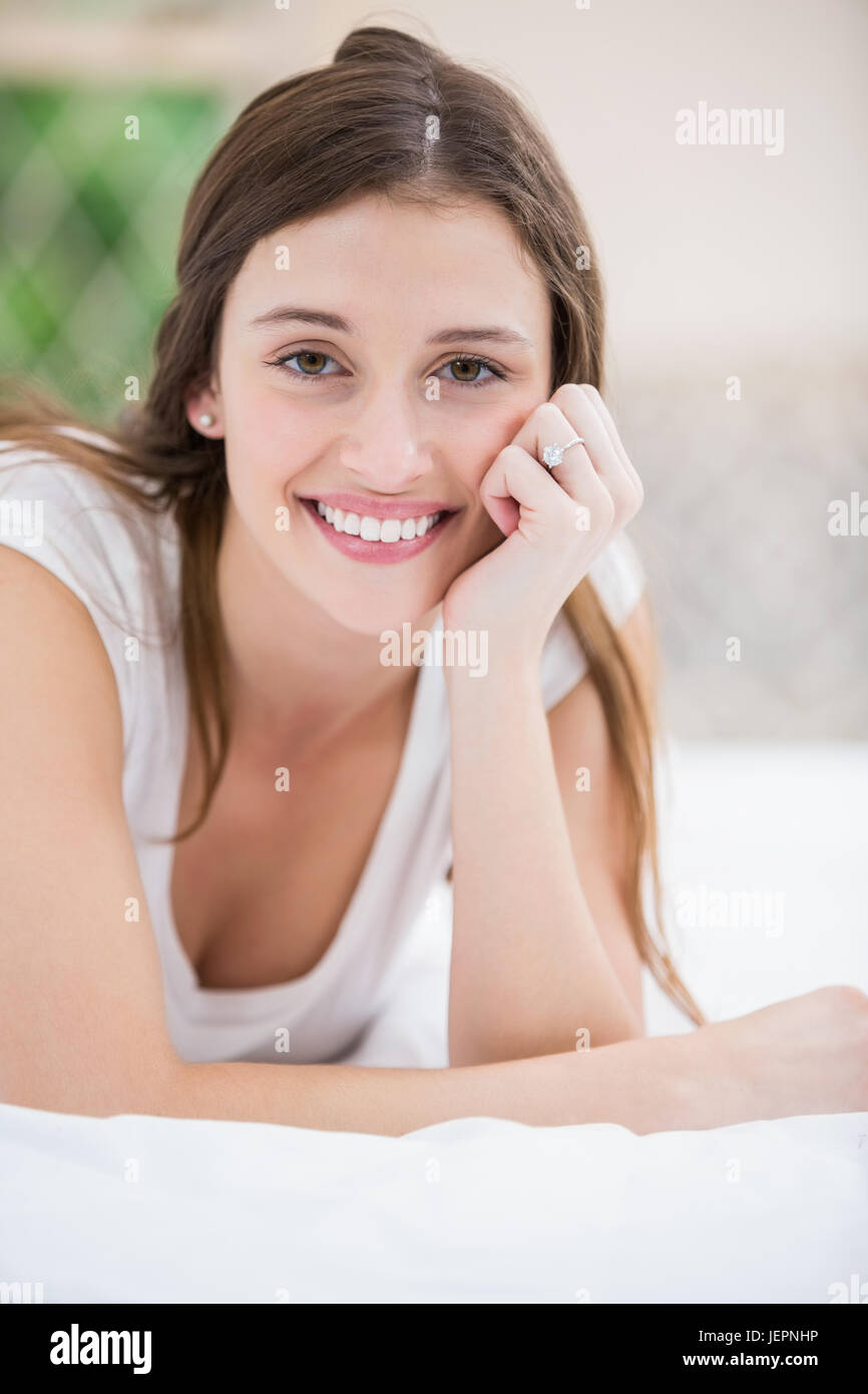 Portrait of smiling woman lying on bed Stock Photo - Alamy