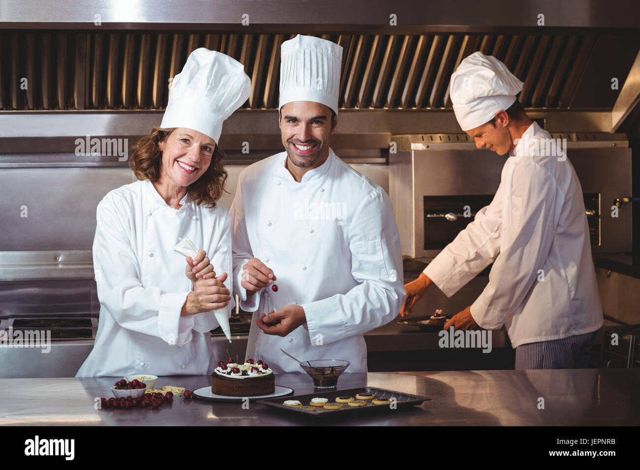 Chefs presenting the cake they just made Stock Photo - Alamy