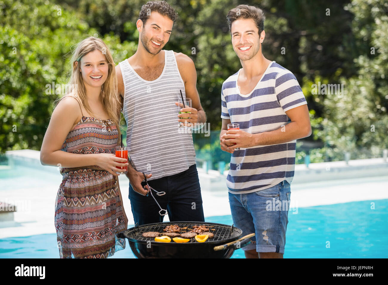 Happy friends preparing barbecue near pool Stock Photo - Alamy