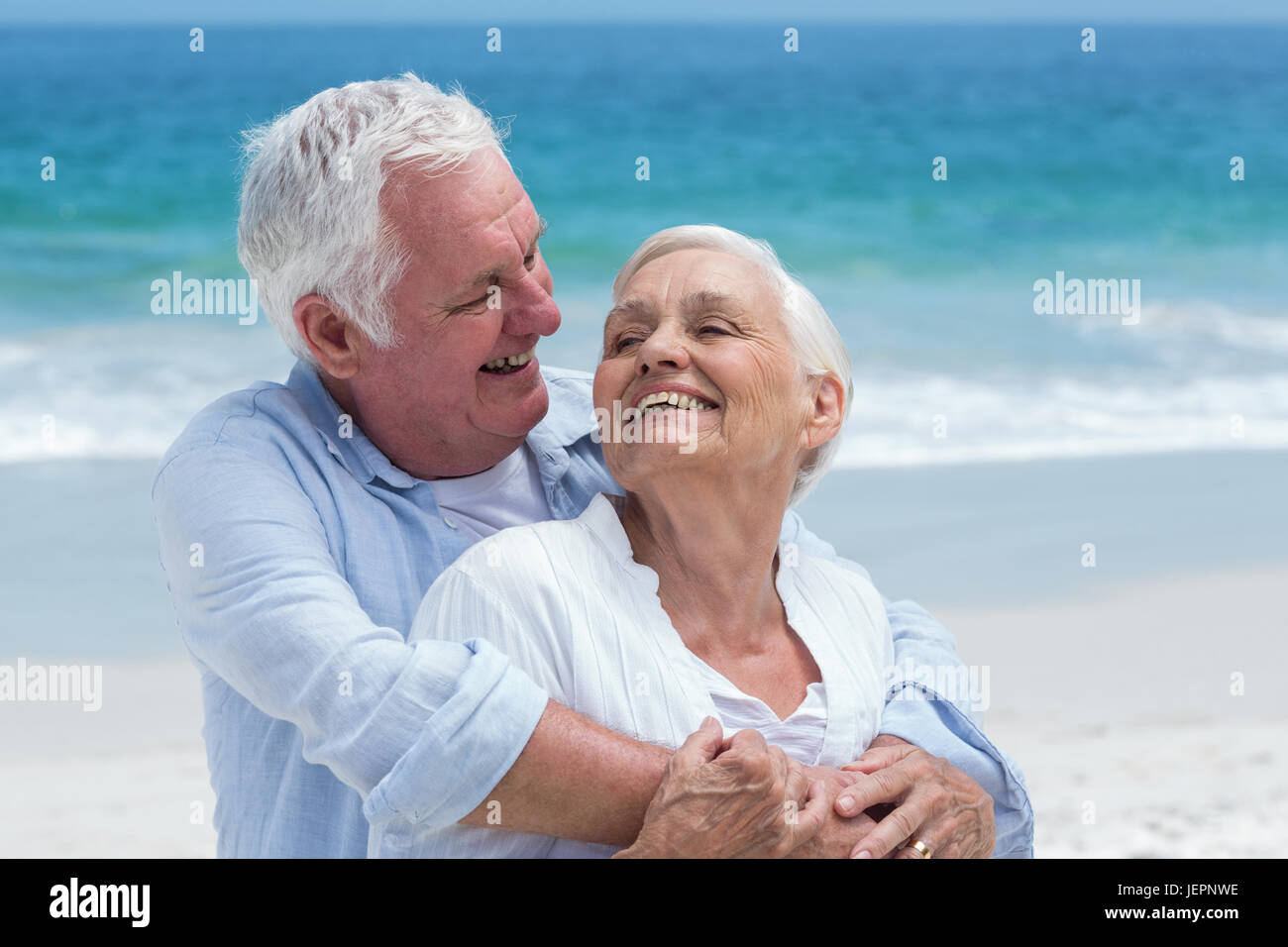Senior couple embracing with arms around Stock Photo - Alamy