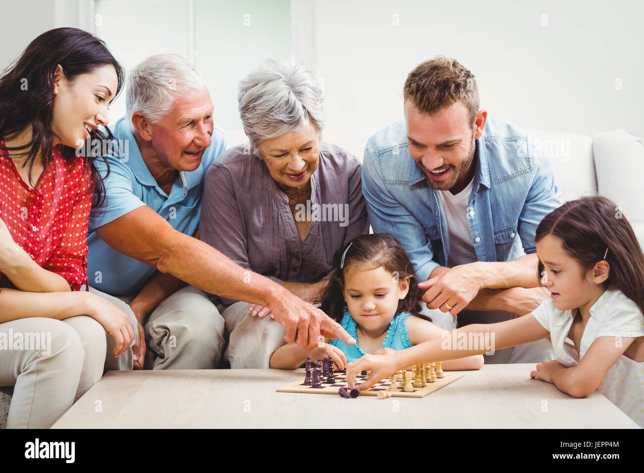 Smiling family playing chess Stock Photo - Alamy