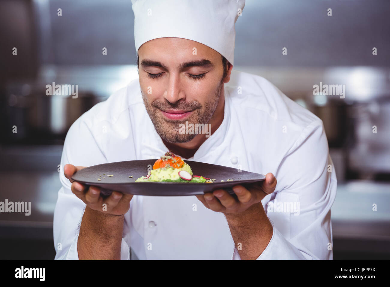 Male chef with eyes closed smelling food Stock Photo - Alamy
