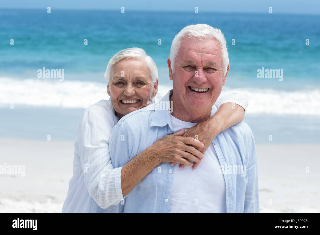 Senior couple embracing with arms around Stock Photo - Alamy