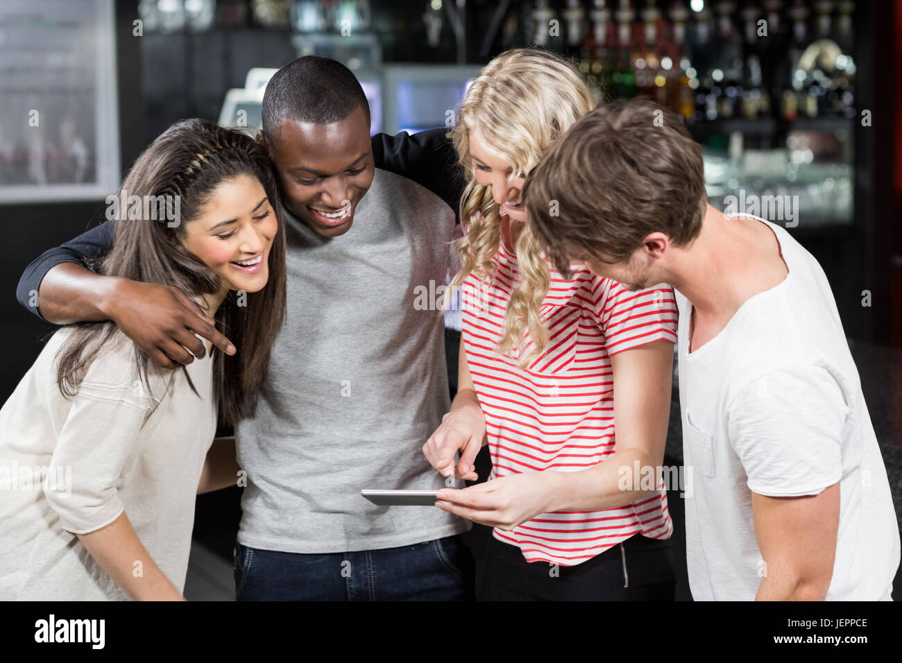 Happy friends using tablet Stock Photo - Alamy
