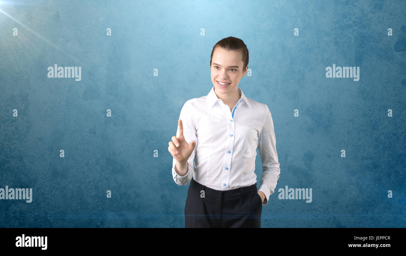 Beautiful business woman is pushing an invisible button in front of the ...