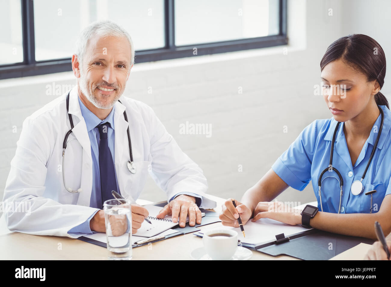 Doctors writing a report in conference room Stock Photo - Alamy