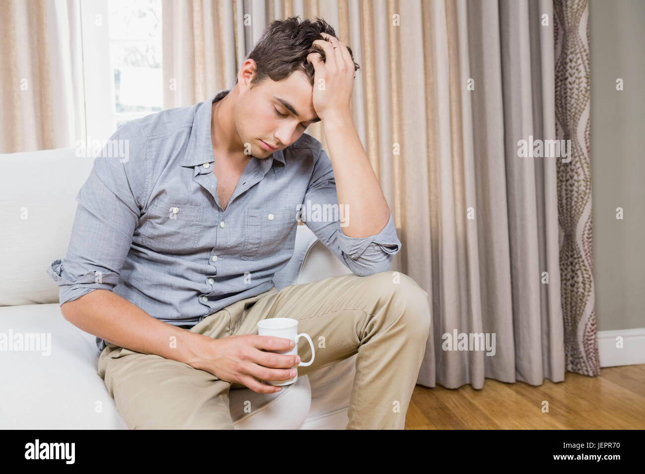 Stressed young man sitting hi-res stock photography and images - Alamy