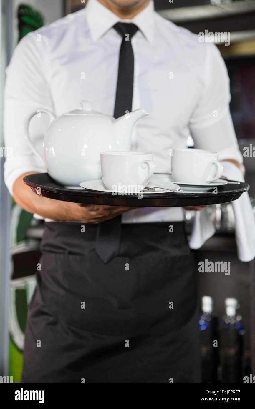 Mid section of waiter serving tea Stock Photo - Alamy