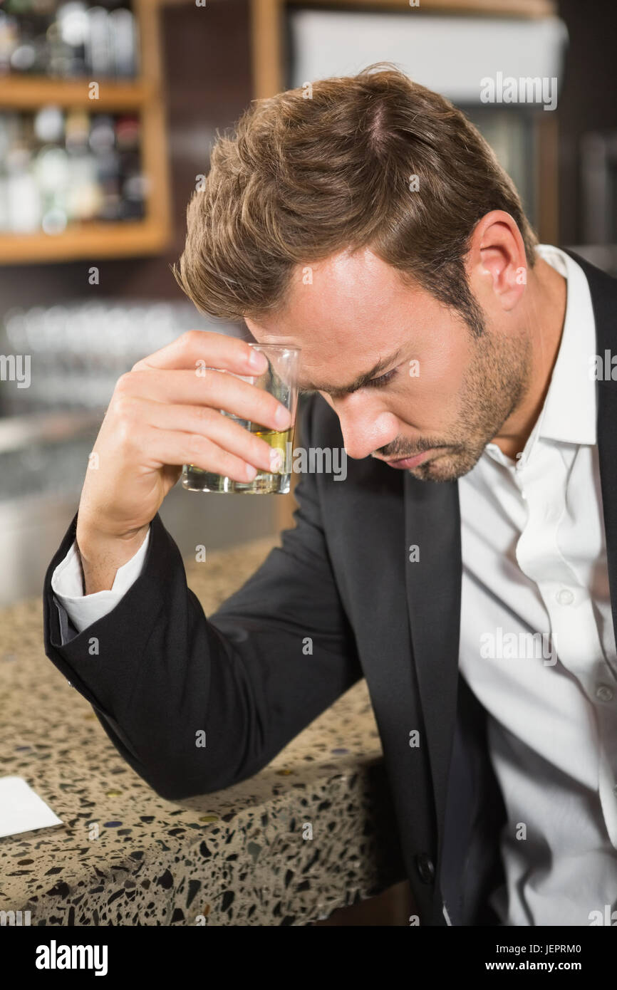 Tired man having a whiskey Stock Photo - Alamy
