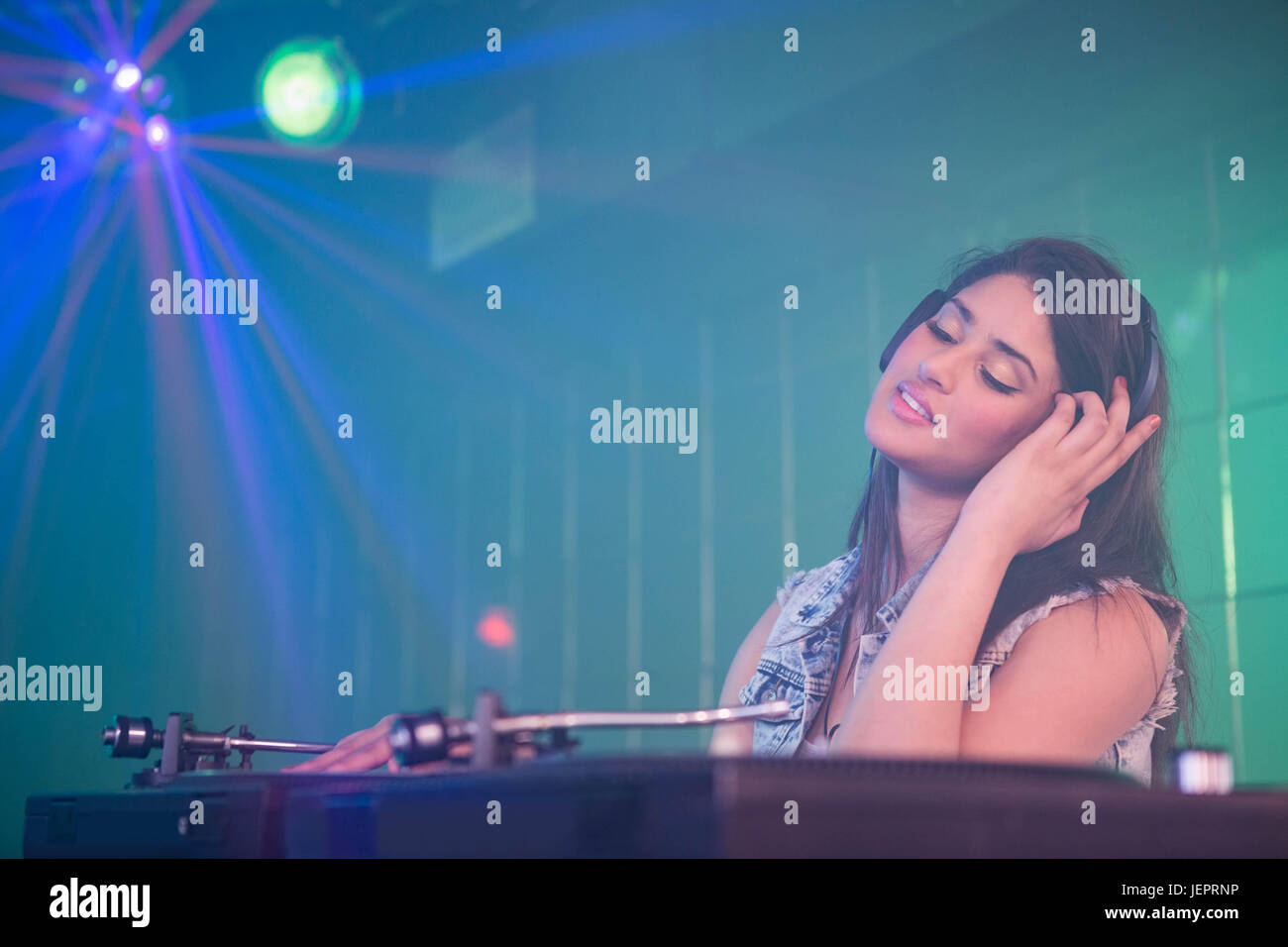 Pretty female DJ playing music Stock Photo - Alamy