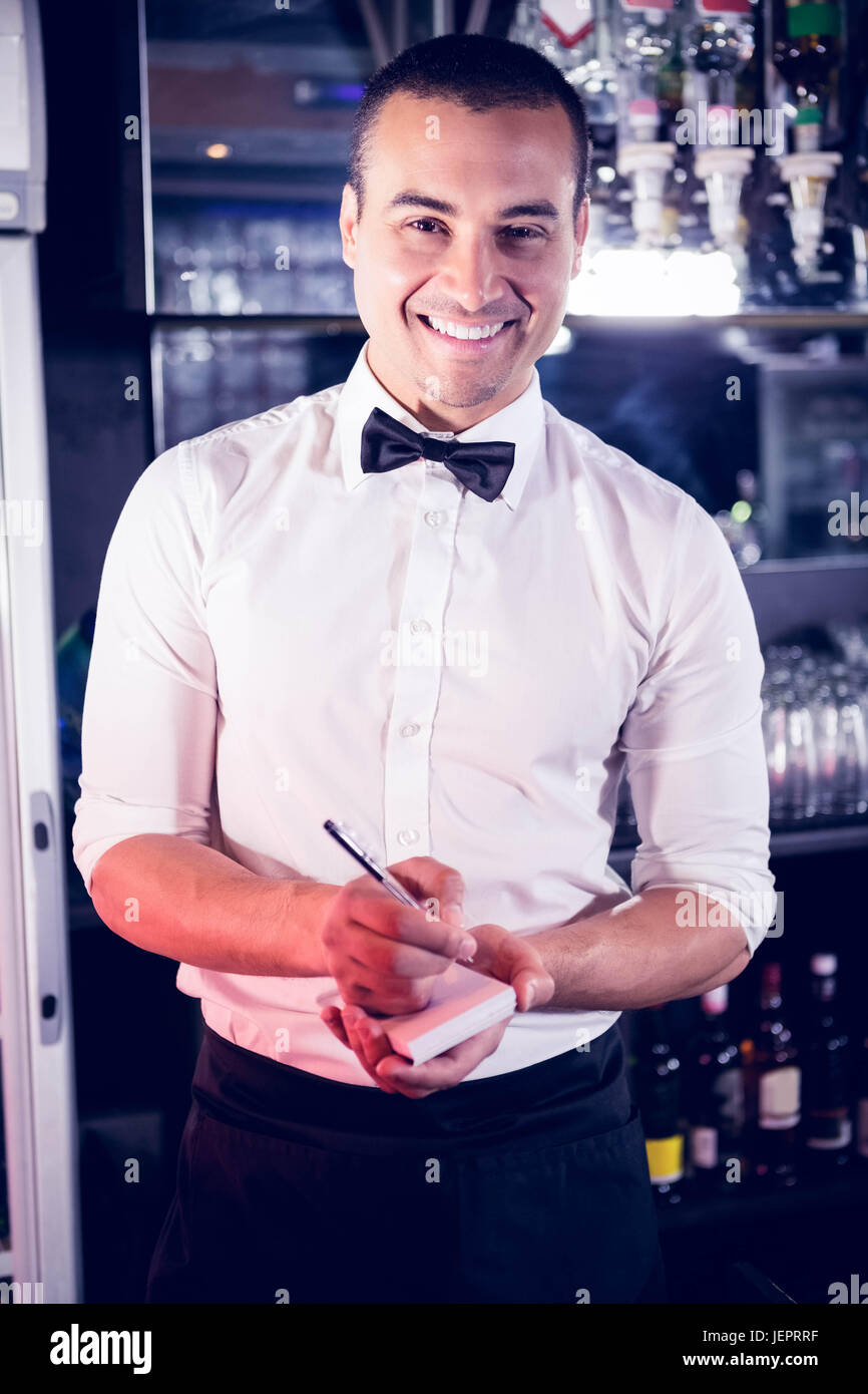 Portrait of a waiter writing down an order Stock Photo - Alamy