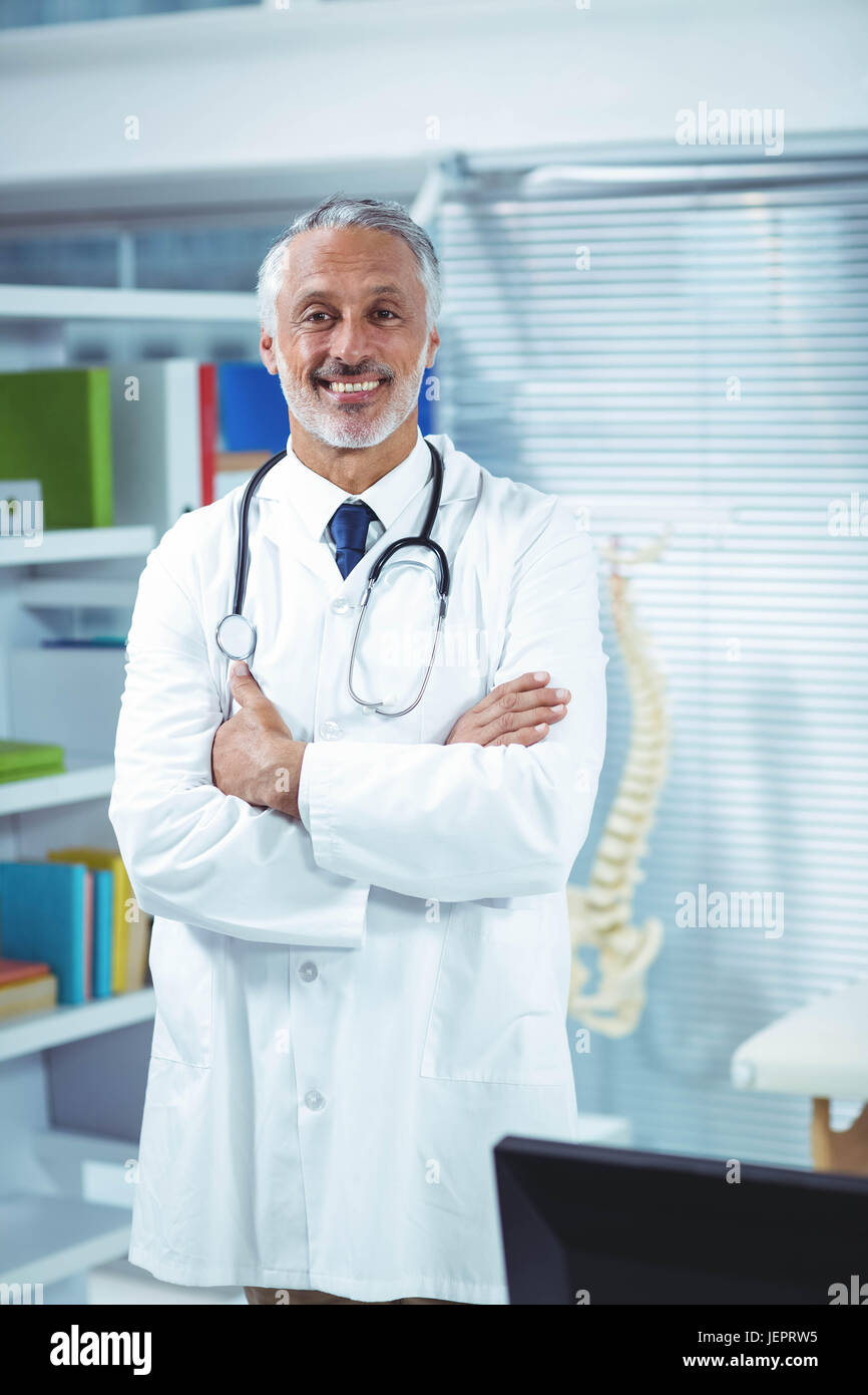 Doctor standing with arms crossed in clinic Stock Photo - Alamy