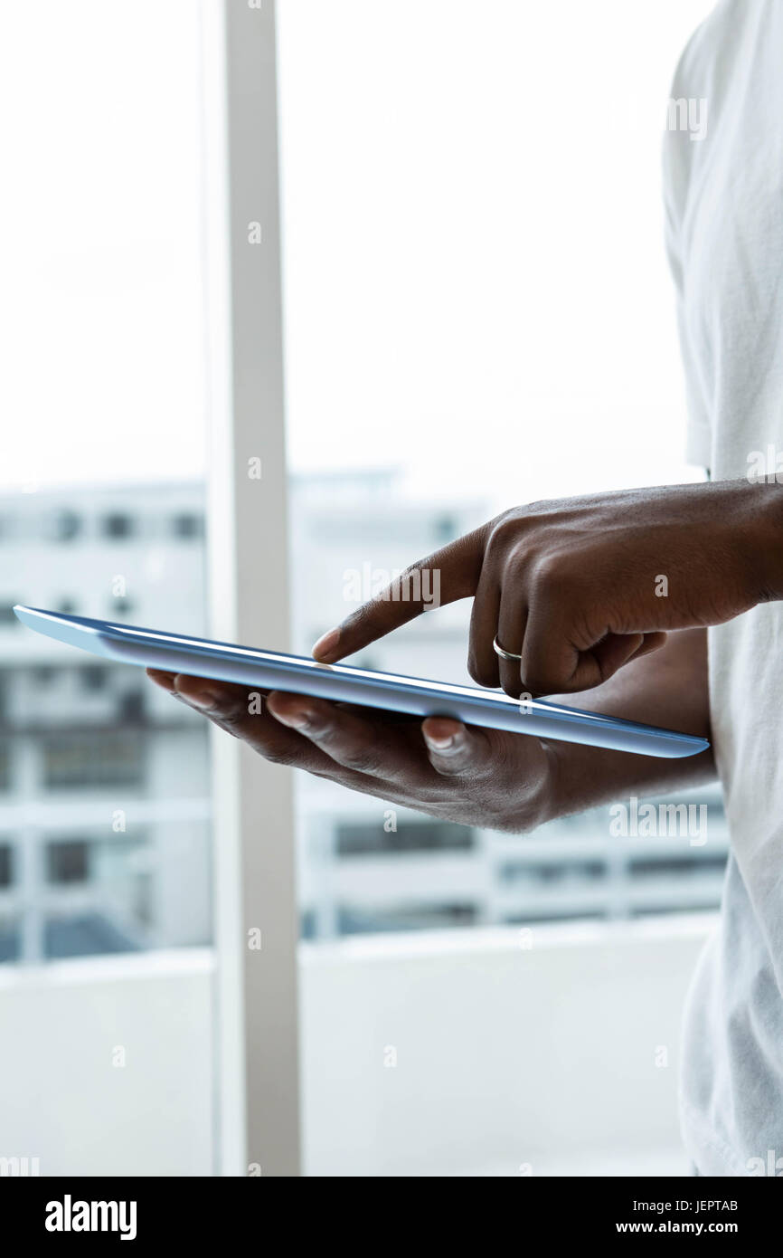 Man using digital tablet near window Stock Photo - Alamy