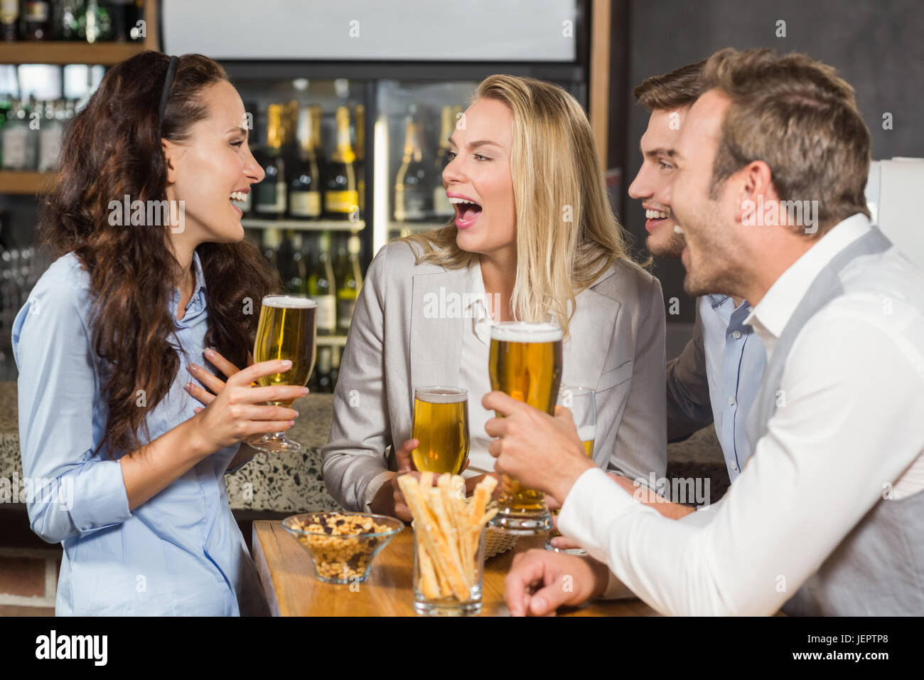 Friends laughing while drinking beer Stock Photo - Alamy