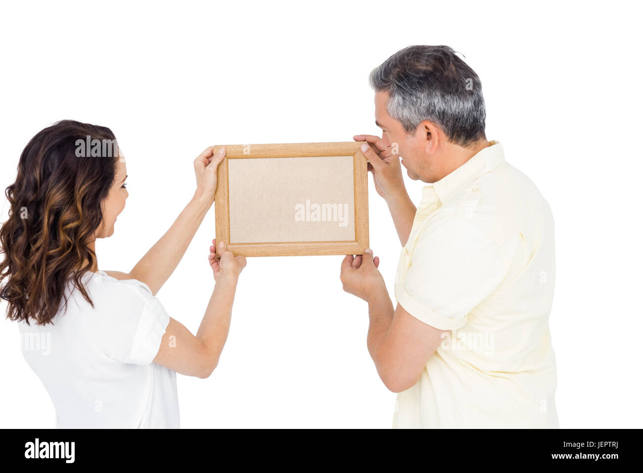 Happy couple holding picture frame Stock Photo - Alamy