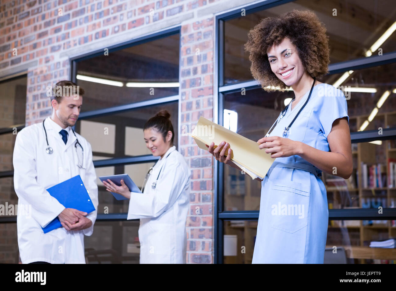 Female doctor checking a file near library Stock Photo - Alamy