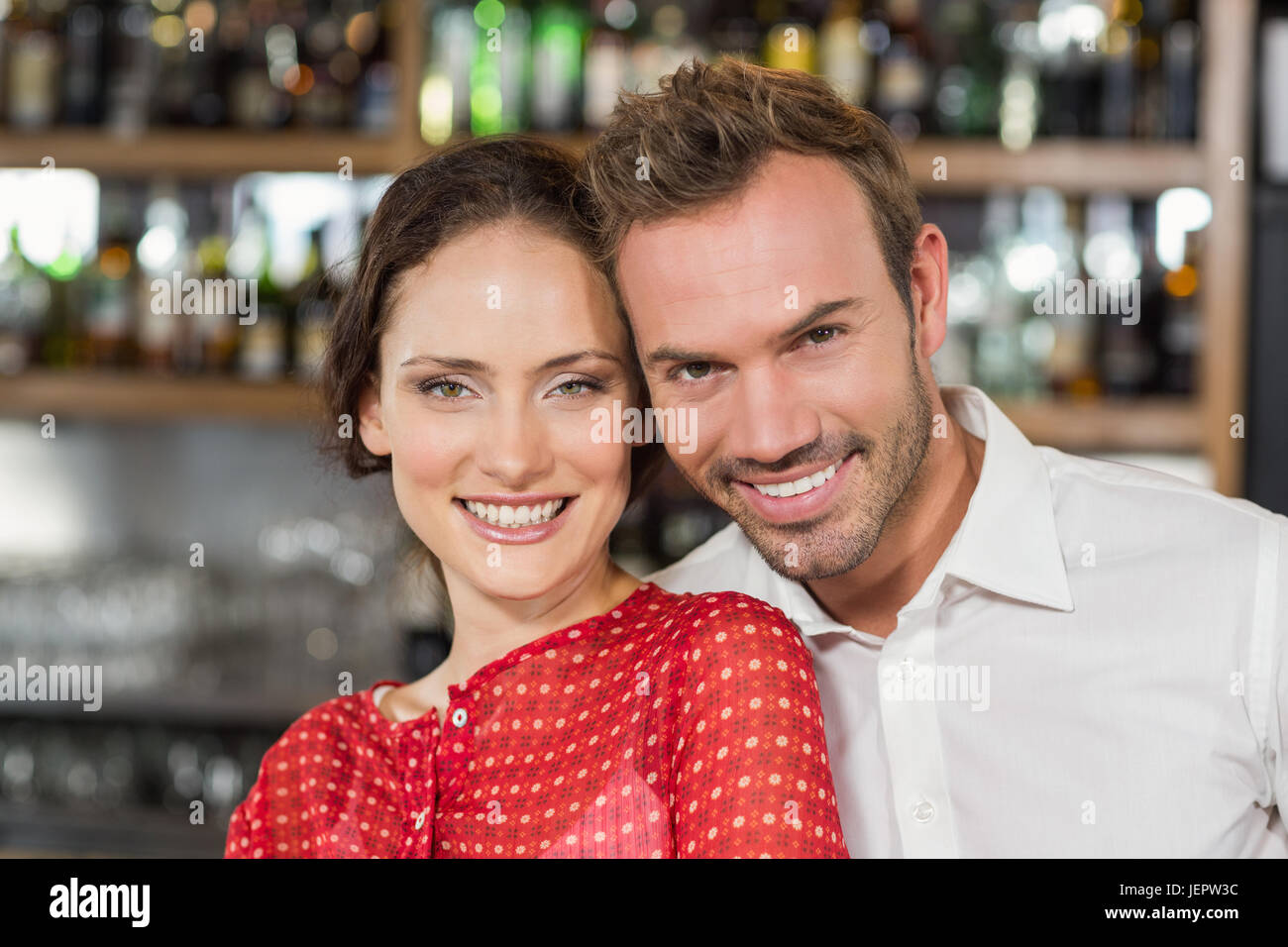 Couple smiling at camera while hugging Stock Photo - Alamy
