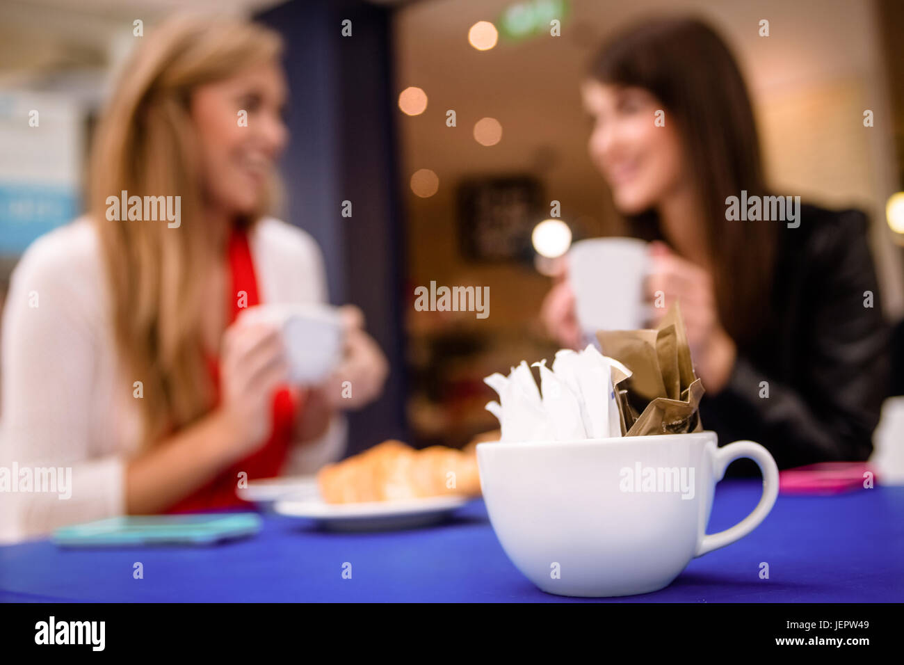 Packets of sugar in a cup on table Stock Photo - Alamy